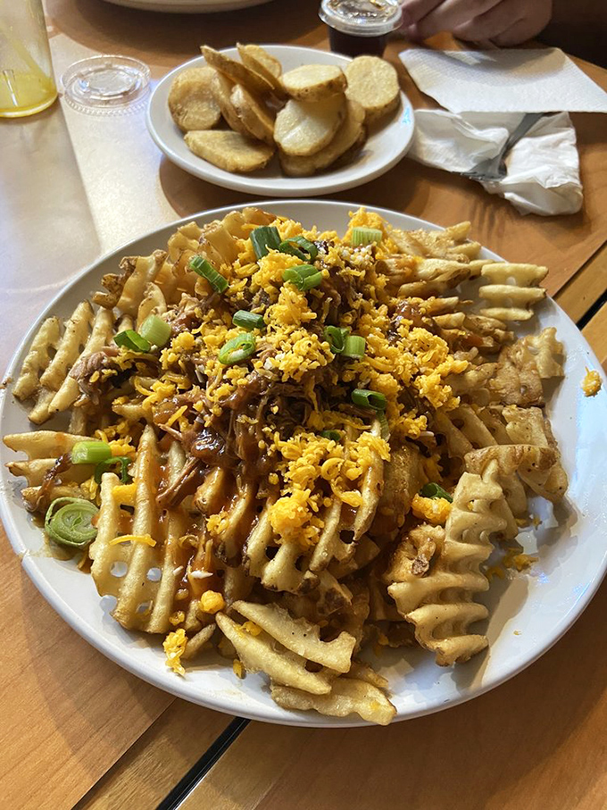 Loaded waffle fries that don't just feed your hunger but your soul – a mountain of comfort topped with cheese, green onions, and pure joy.