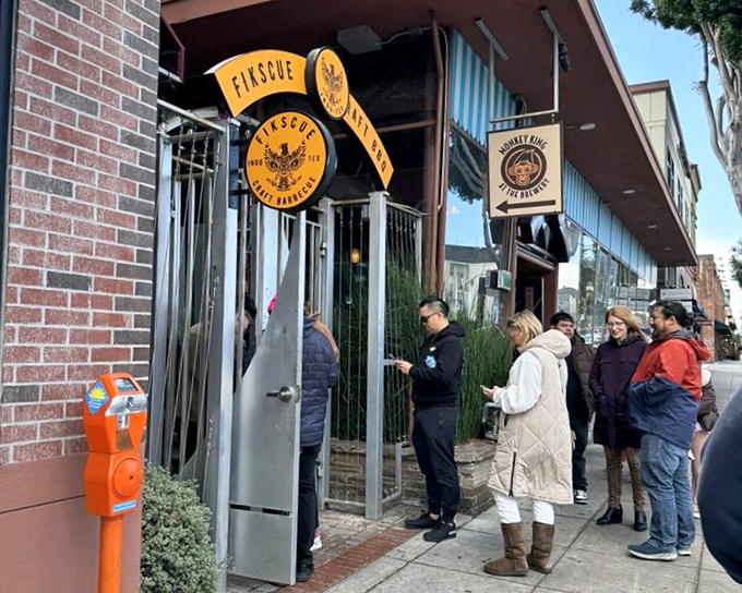 Fikscue’s brick facade and yellow awning signal BBQ seriousness, with a line of hungry guests streaming through the door.