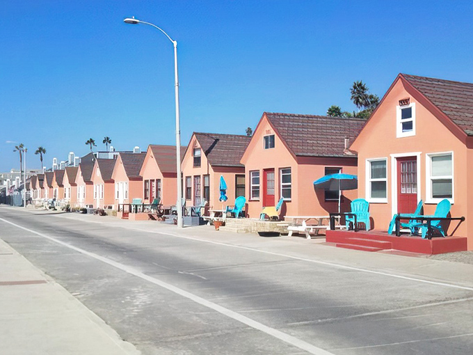Colorful beach cottages line up like a rainbow of coastal dreams come true.