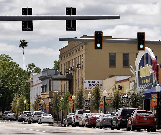 Downtown street in a Florida small town with historic buildings, including Linda's Books and lined with parked cars.