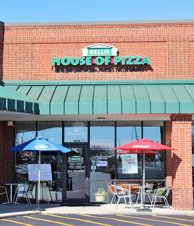 Red umbrellas and outdoor tables invite you to enjoy Bellis' legendary Greek-style pizza under South Carolina skies.