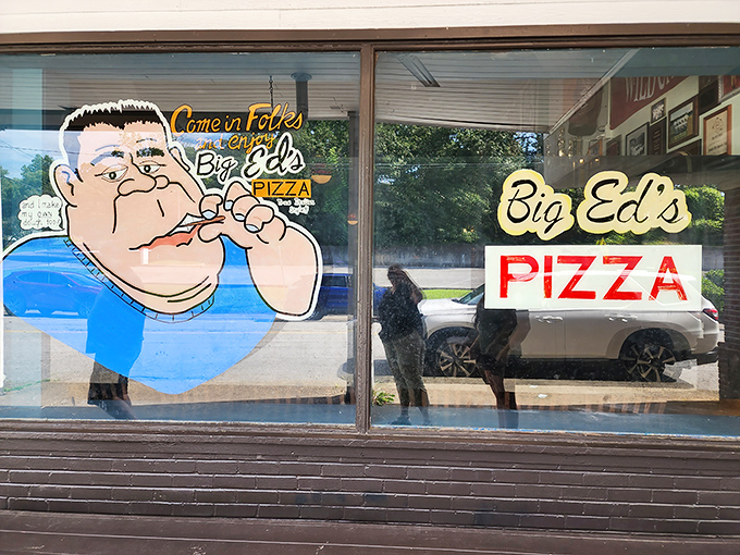 The window art at Big Ed's tells you everything—this place doesn't take itself seriously, just its pizza. That cartoon face has witnessed countless first bites.