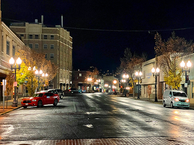 Rain-soaked pavement reflecting neon—Blade Runner vibes, but with small-town heart instead of dystopian grit.