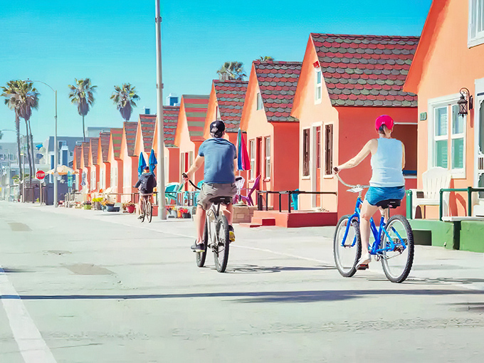 Cyclists pedal past cheerful beach houses in this slice of seaside retirement heaven.