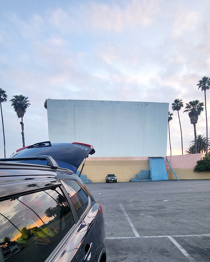 Movie magic under the stars! Rubidoux Drive-In's massive screen comes alive as darkness falls over eager viewers.