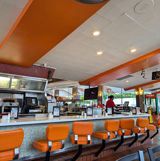 Those orange counter stools have witnessed countless conversations, from philosophical debates to hungover twenty-somethings seeking pancake salvation.