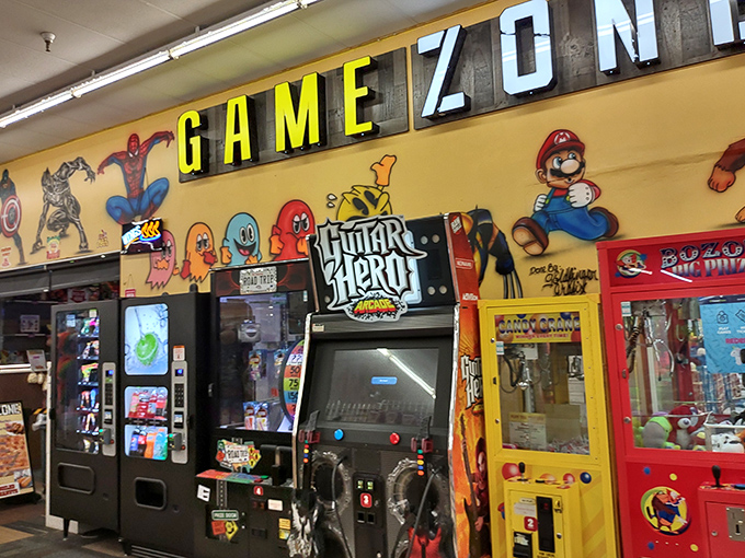 The "Game Zone" arcade corner—where quarters disappear faster than cake at a birthday party, but the nostalgic joy is absolutely priceless.