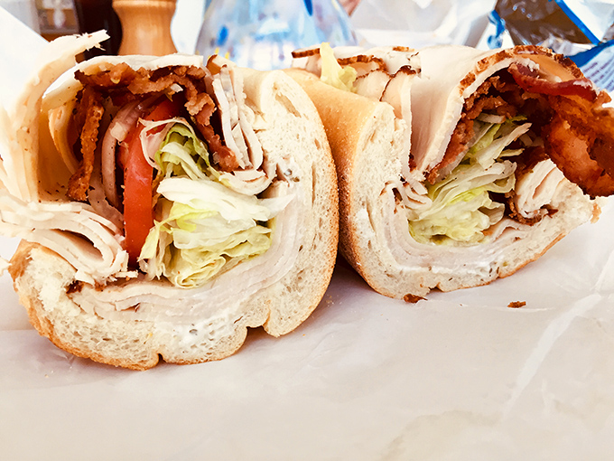 This sandwich isn't just lunch &ndash; it's architecture. Perfectly stacked turkey, crisp lettuce, and fresh tomato in cross-section glory.