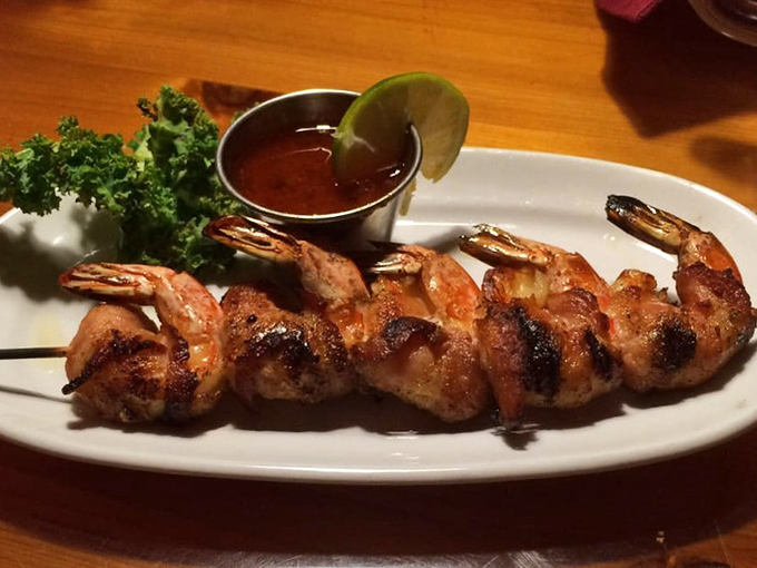 Grilled shrimp skewers – charred in all the right places – served with a dipping sauce that makes you consider drinking it straight.