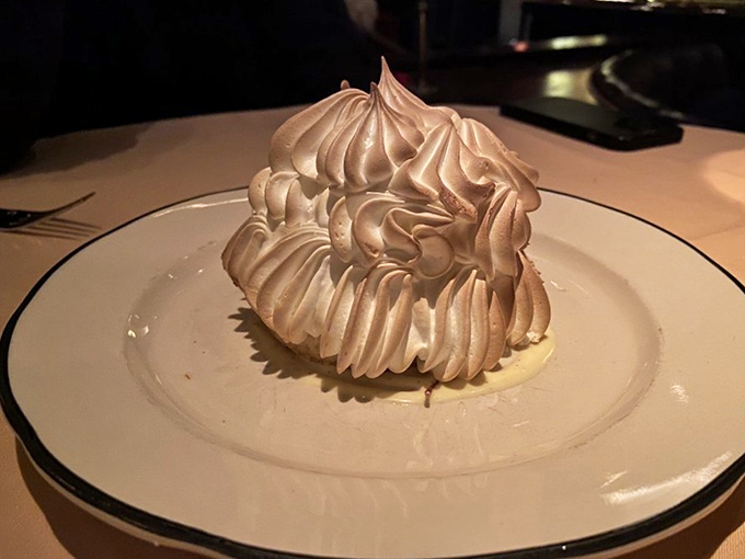 The Baked Alaska stands tall and proud, its toasted meringue peaks resembling a delicious snow-capped mountain. Dessert architecture at its finest.