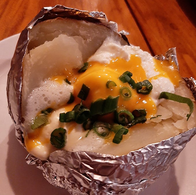 Not just a baked potato &ndash; it's a canvas of comfort topped with a melting sunset of cheddar and green onion confetti.