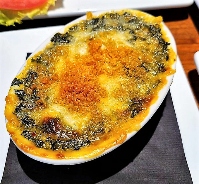 Bubbling cheese, vibrant greens &ndash; this baked spinach dish is what Popeye would order if he had a 401k and good taste.