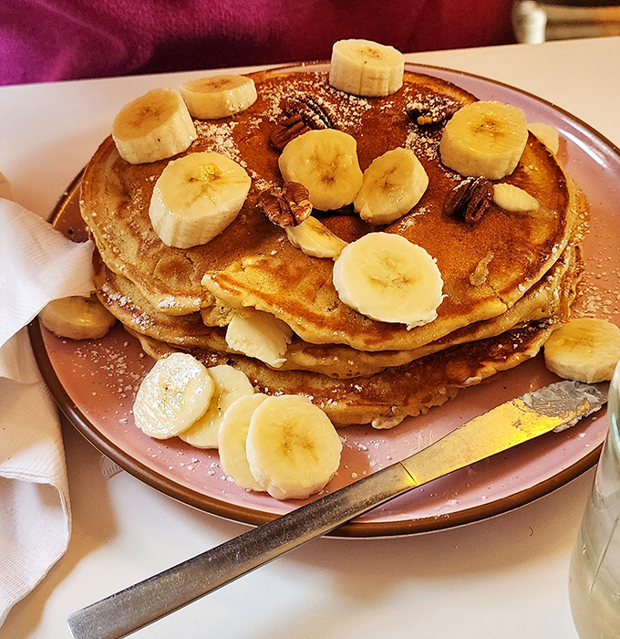 Banana nut pancakes stacked higher than your weekend expectations, with enough fruit to convince yourself it's practically health food.