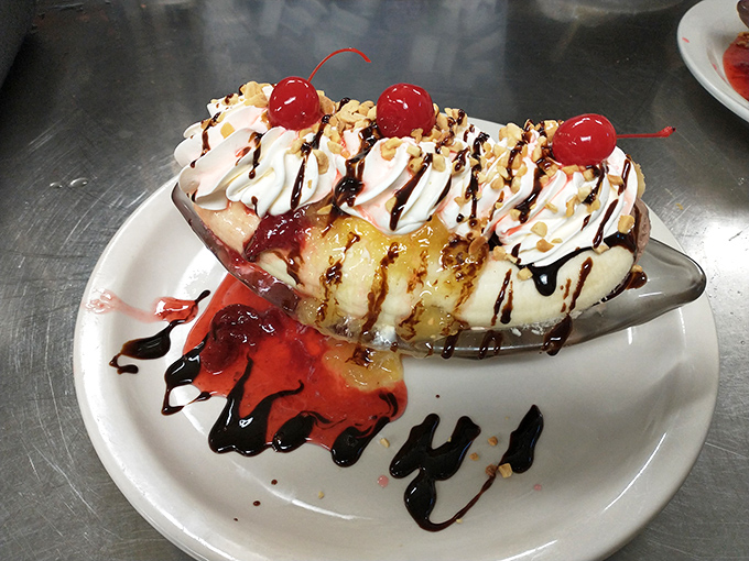 The banana split arrives like a dessert parade, complete with chocolate drizzle confetti and cherry-topped whipped cream floats.