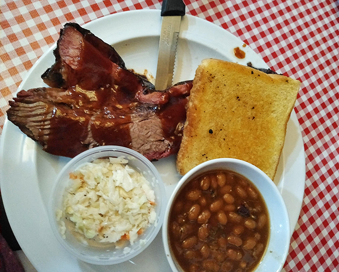 This brisket plate showcases the holy trinity of barbecue: smoky meat, tangy beans, and buttery Texas toast perfection.