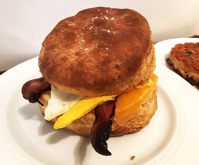 The humble biscuit sandwich, elevated to an art form with layers of egg, cheese, and meat nestled between buttery, flaky goodness.