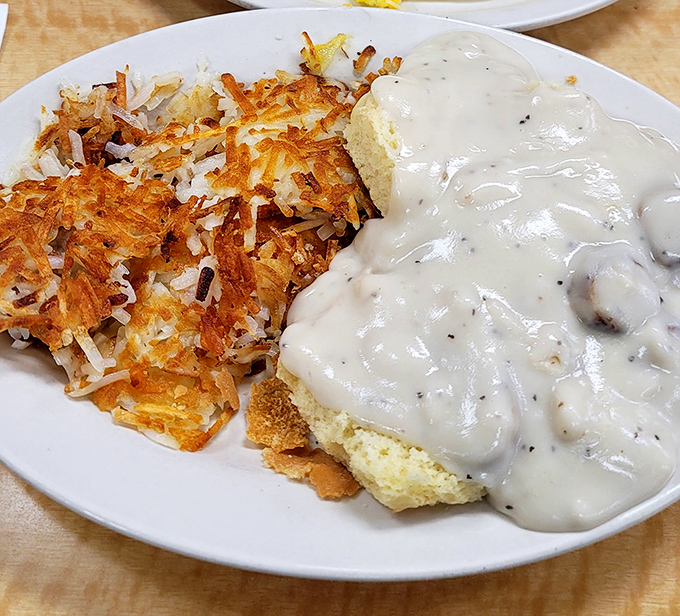Biscuits and gravy alongside perfectly crisped hash browns&mdash;the kind of plate that makes you want to hug the cook and thank their ancestors.