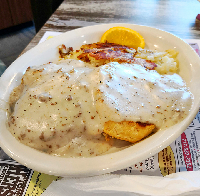 Biscuits buried under an avalanche of peppery sausage gravy – the kind of breakfast that requires both a fork and a nap afterward.