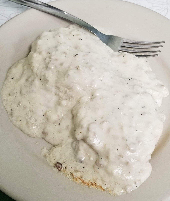 Biscuits and gravy: the breakfast that hugs you from the inside. This plate contains more comfort than an entire self-help section at the bookstore.