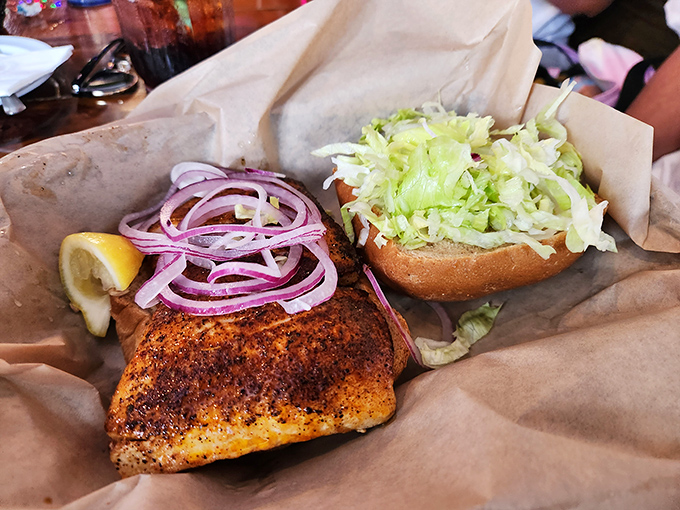 This blackened mahi-mahi sandwich isn't just food – it's a spice-crusted vacation between two pieces of bread, complete with crisp lettuce and red onion.