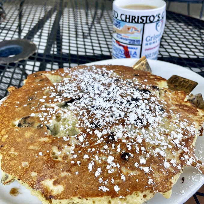 These pancakes aren't just a meal, they're a fluffy canvas sprinkled with powdered sugar and served with Christo's signature coffee.