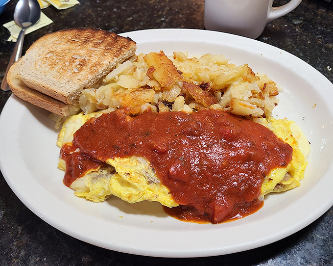 The holy trinity of breakfast: eggs, potatoes, and toast, with a splash of marinara adding that unexpected plot twist your morning needs.
