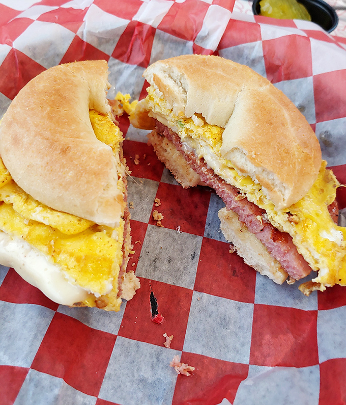 The breakfast sandwich in its natural habitat &ndash; a red checkered wrapper. That cross-section reveals the holy trinity: fluffy egg, melty cheese, and savory meat.