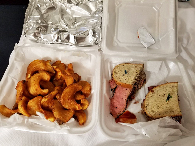 The takeout experience: curly fries that defy gravity alongside a sandwich that requires both hands and your full attention.