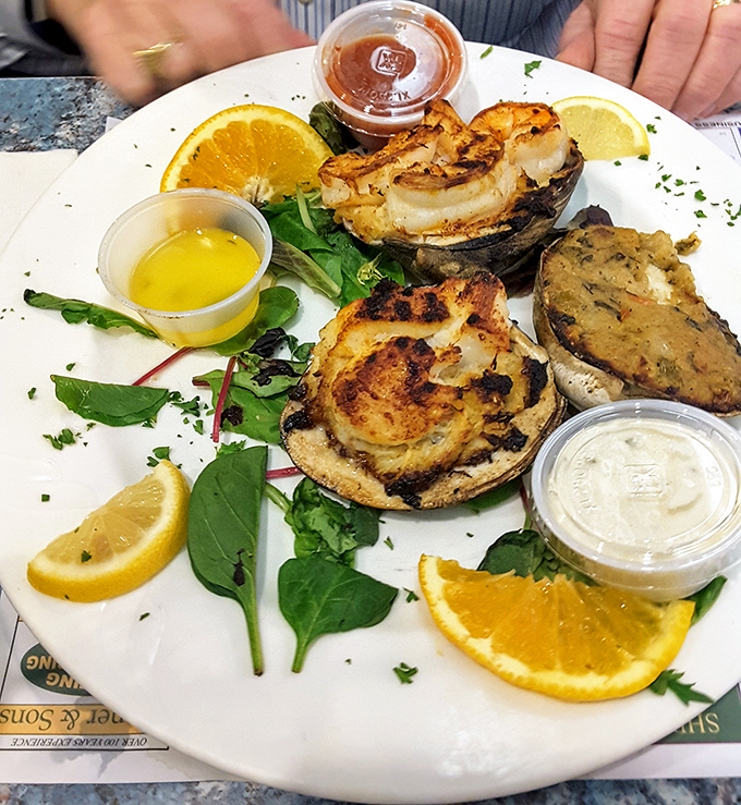 Broiled crab cakes presented with the ceremony they deserve&mdash;golden-brown treasures surrounded by citrus slices like culinary spotlights.