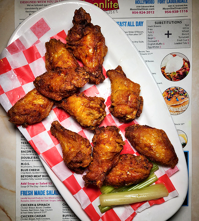 Fried chicken wings with a crunch so satisfying you'll hear it echo in your dreams&mdash;served on checkered paper because some traditions matter.