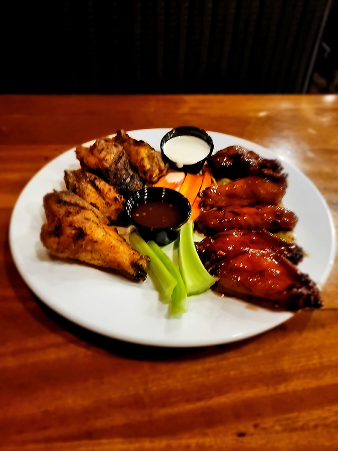 The wing sampler arrives like a flavor United Nations, with dipping sauces playing the role of diplomatic relations between Buffalo and your appetite.