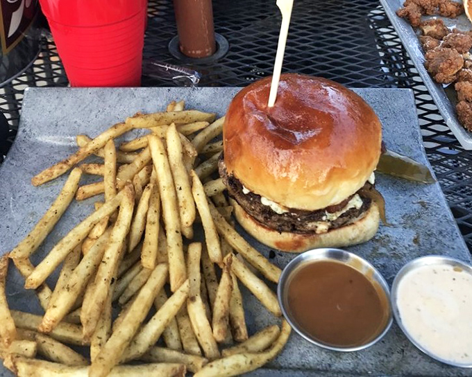 The Buford Blues burger arrives with perfect golden fries. That glossy bun and those sauces are about to create a beautiful mess.