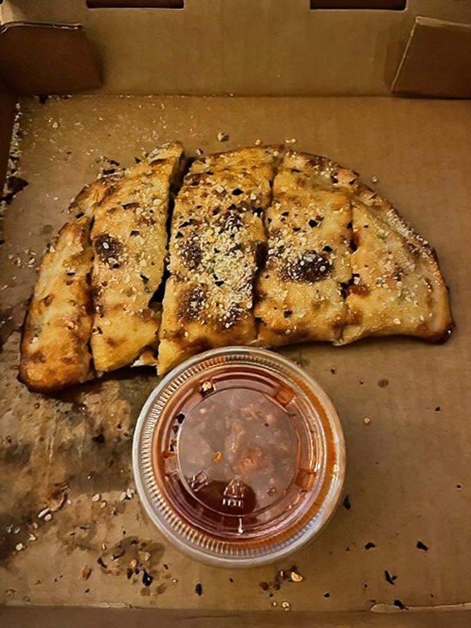 The calzone&mdash;pizza's sophisticated cousin who went to finishing school&mdash;arrives golden-brown with a side of dipping sauce that demands to be savored.