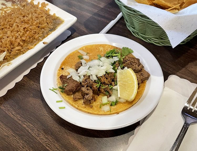 Sometimes perfection requires only five ingredients: a handmade tortilla, perfectly seasoned meat, fresh cilantro, diced onion, and a lime wedge for brightness.