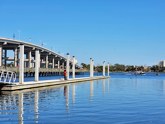 Morning light dances across the Halifax River while the bridge stretches toward the horizon like a concrete rainbow promising treasures on the other side.