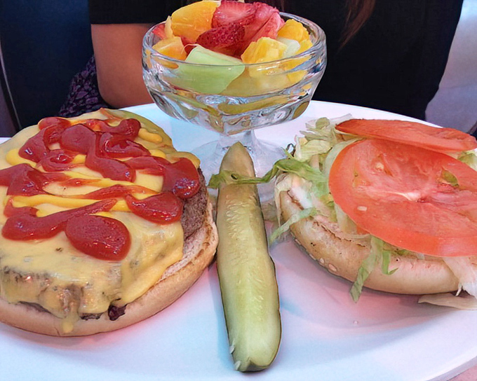 A burger that looks like it stepped out of a Norman Rockwell painting, with a fresh fruit medley playing backup.