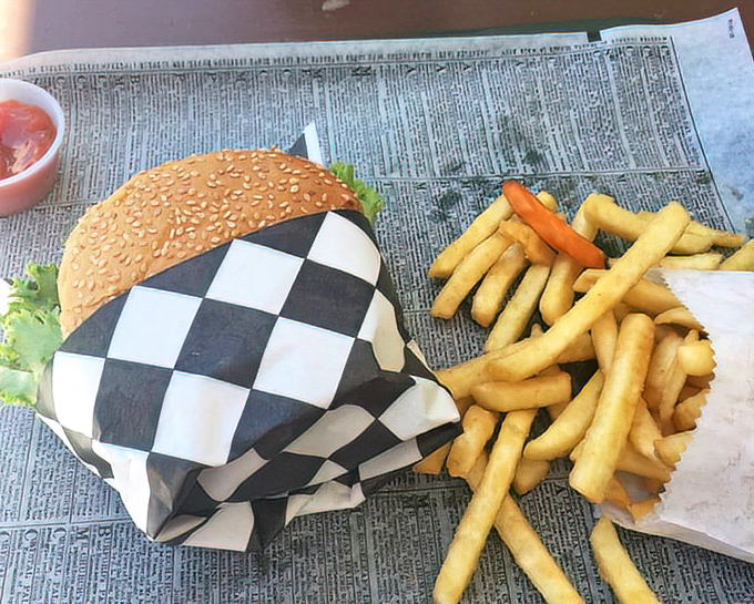 The classic cheeseburger arrives wrapped in checkered paper&mdash;like receiving a gift that happens to be edible paradise.
