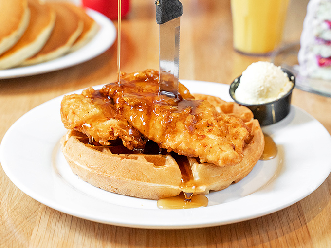 The ultimate breakfast rebellion: crispy fried chicken atop a golden waffle, with maple syrup cascading down like a sweet waterfall.