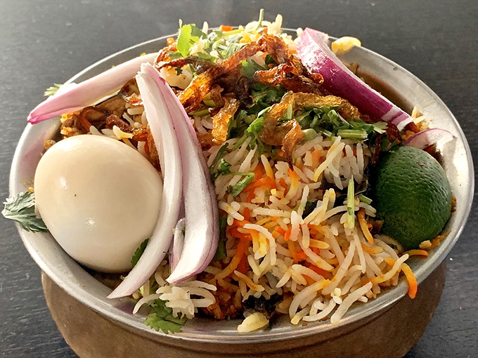 Biryani with all the fixings &ndash; the hard-boiled egg and raw onions are like the backup singers that make the star shine even brighter.