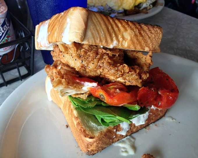 A sandwich that requires both hands and a strategy. Crispy chicken, fresh veggies, and toasted bread—the holy trinity of lunch perfection.