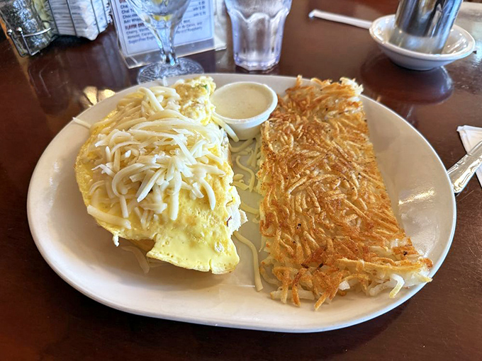 An omelet and hash browns that make you question why you ever eat anything else for breakfast. That cheese pull deserves its own Instagram account.