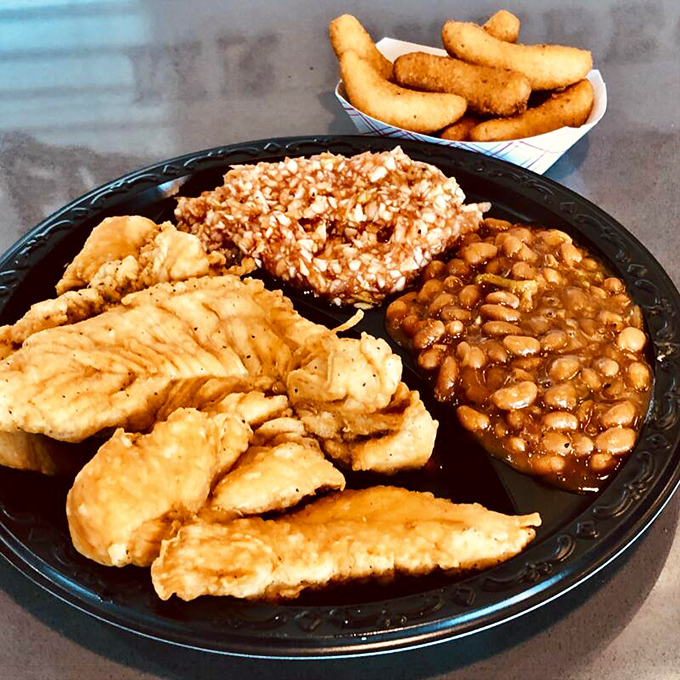 A plate that doesn't mess around: tender chicken, rice, beans, and those legendary hush puppies standing guard on the perimeter.