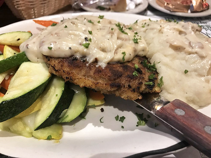 The star attraction: chicken fried steak with creamy country gravy alongside fresh vegetables. Crispy, tender, and utterly irresistible.
