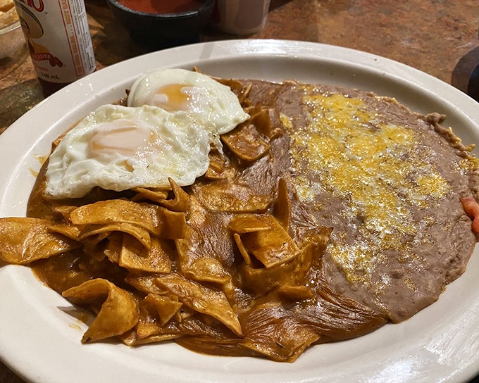 Chilaquiles with eggs—breakfast that answers the eternal question: "Why can't every morning start with crispy tortillas bathed in savory sauce?"