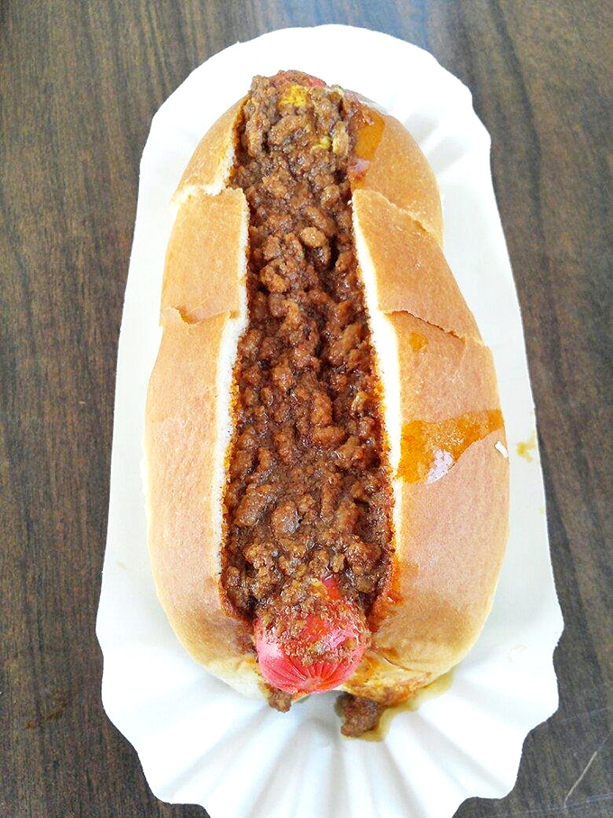 When chili cascades over a hot dog like Niagara Falls, you know you're in for a deliciously messy adventure worth every napkin.