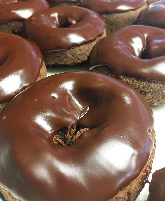 Chocolate donuts gleaming like vinyl records of deliciousness. Each one promises a greatest hit of cocoa satisfaction that never goes out of style.