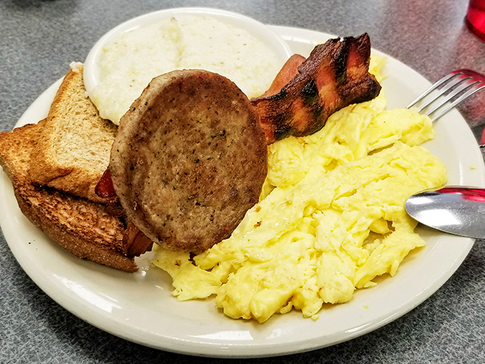 The breakfast trinity: perfectly scrambled eggs, crispy bacon, and toast. Add grits, and you've got a Southern morning on a plate.