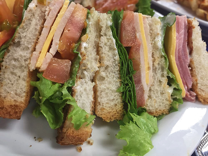 The club sandwich—architecture you can eat. Layers of ham, turkey, and cheese creating the skyscraper of sandwiches that's worth every napkin.