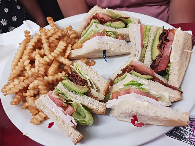 The club sandwich: architectural marvel of the lunch world. Those crinkle-cut fries aren't just sides&mdash;they're supporting characters in this midday drama.