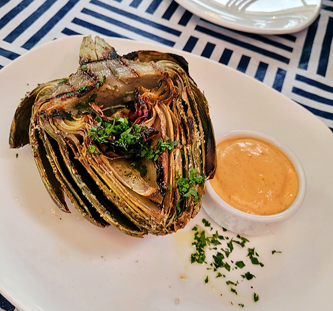 The humble artichoke, split and grilled until its edges caramelize, becomes a smoky vessel for that addictive dipping sauce.